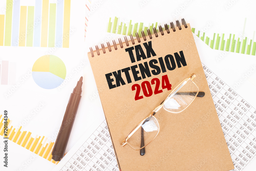 In a craft colour notebook is a TAX EXTENSION 2024 inscription, next to ...