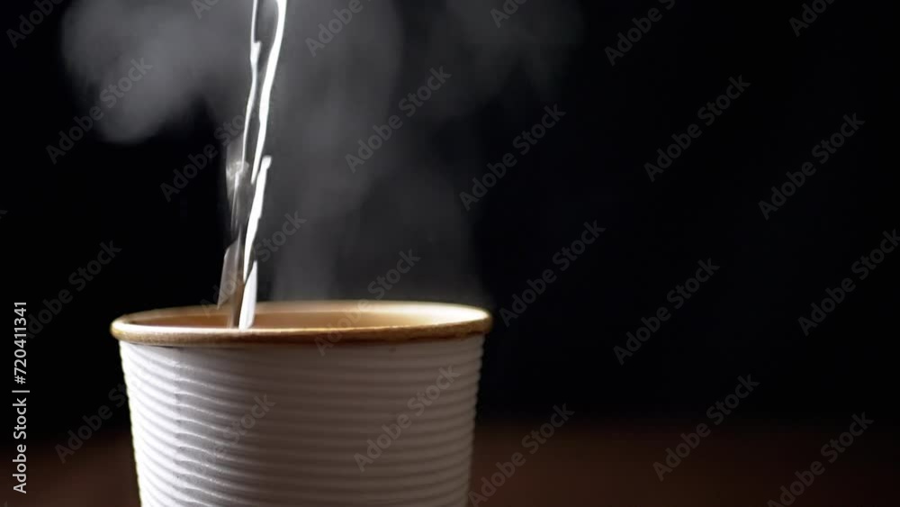 Brewing Hot Tea in a Paper Cup on a Black Background. A stream of hot ...