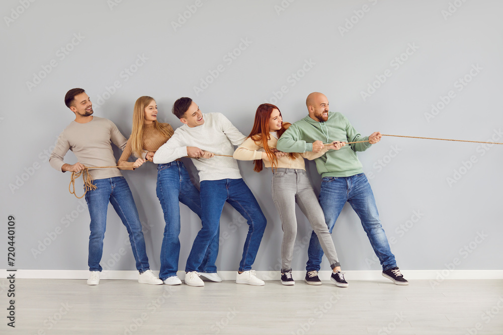 Group of happy friends playing tug of war and having fun together. Team ...
