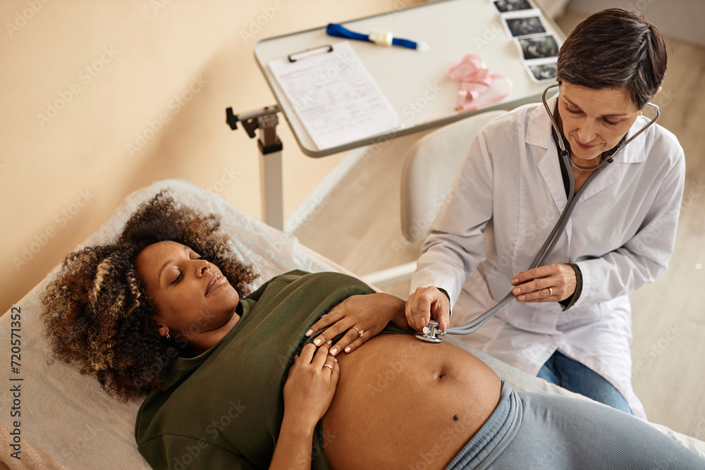 Top down view of pregnant Black woman lying on examination table in ...