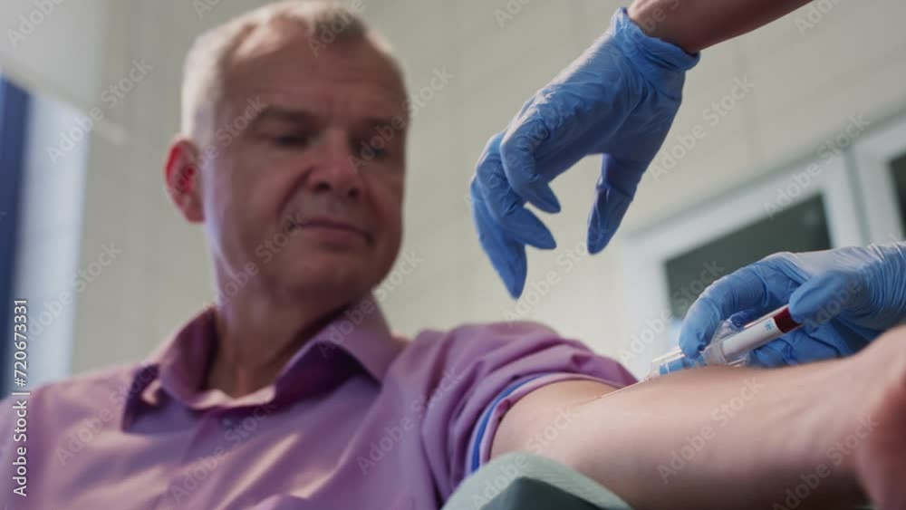 Blood collection from a old man in a clinic or hospital. A doctor ...