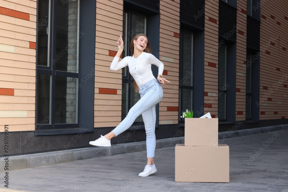 Pretty young woman is holding box with decor for home and standing at ...