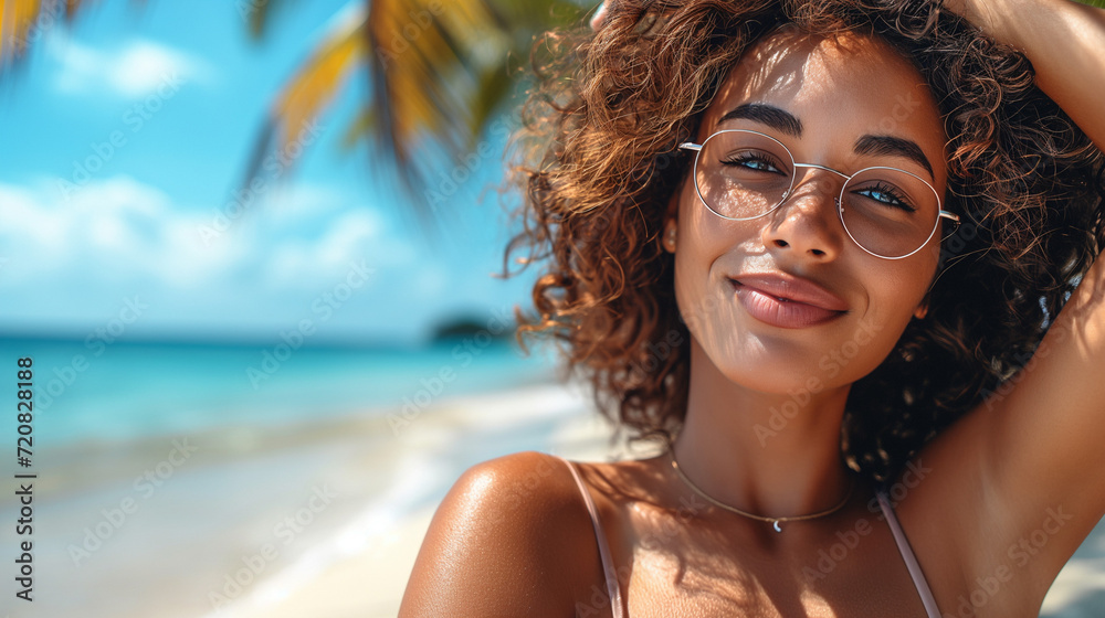 A young woman on the beach in summer, relaxing in a sun lounger ...