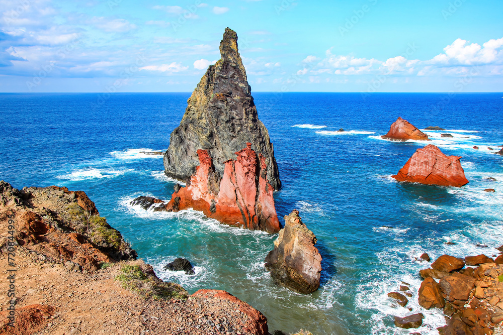 Red rock pillar protruding out of the Atlantic Ocean at the Ponta de ...