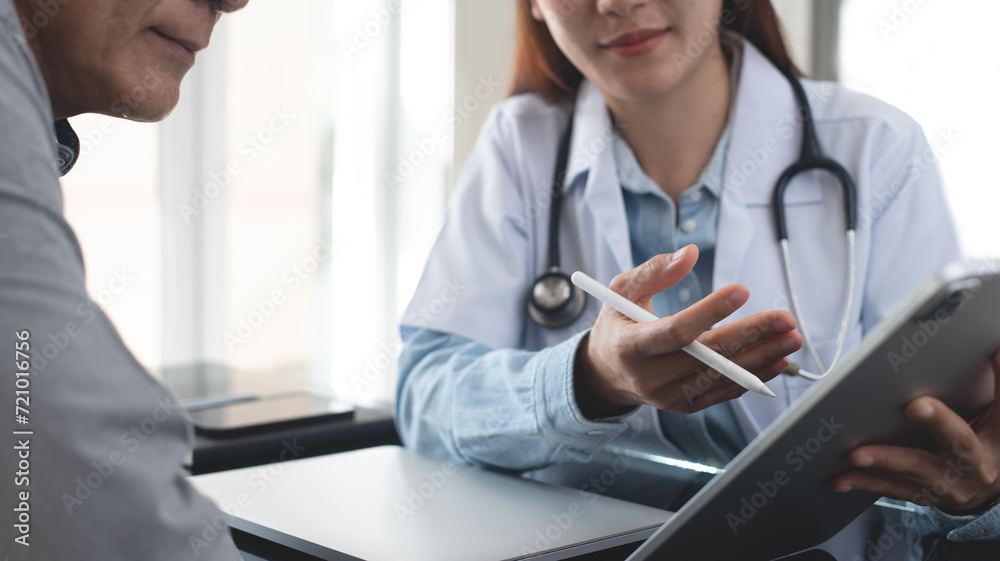 Female asian smiling doctor showing digital tablet screen to patient ...
