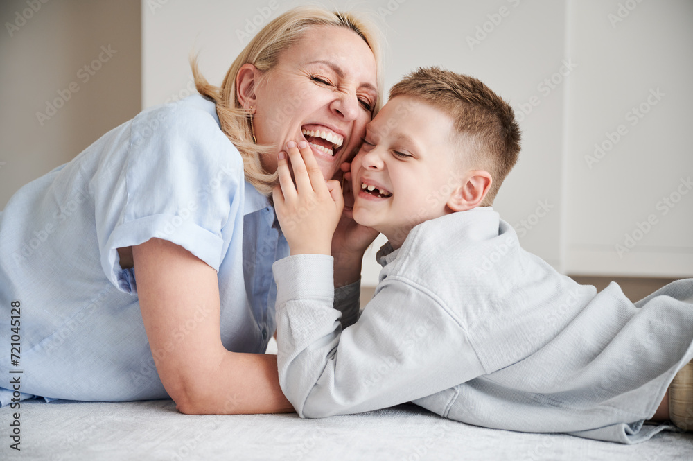 Joyful mom laughing with her son. Lovely moment of young mother and her ...