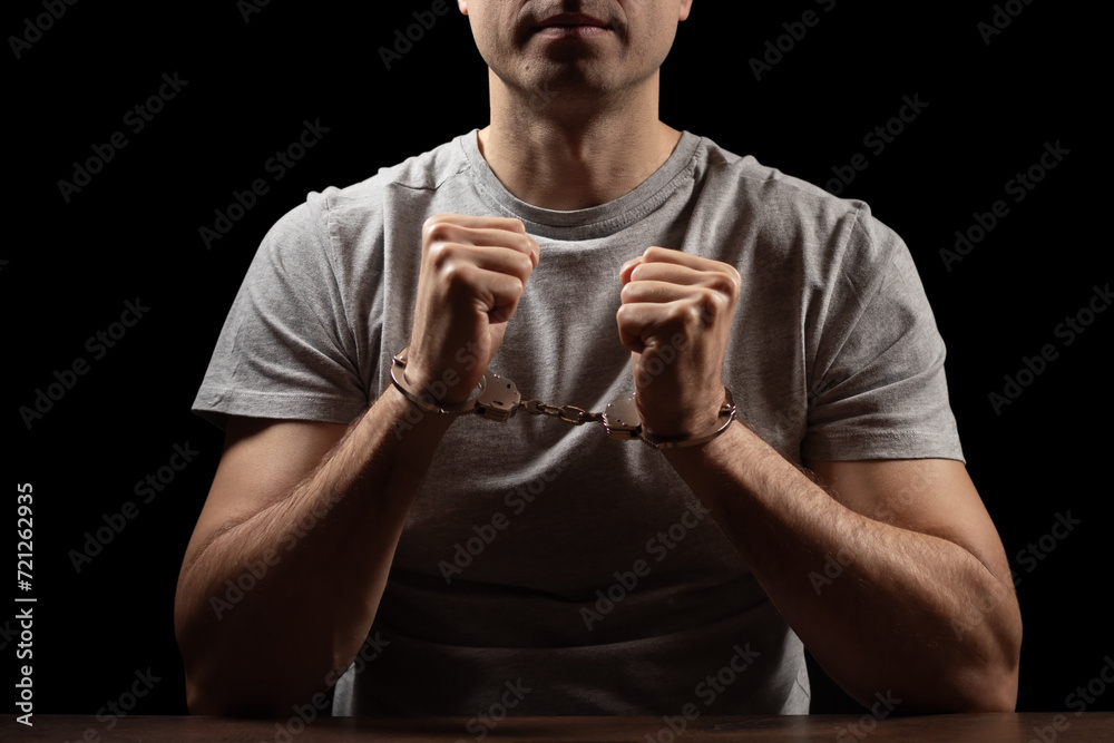 The arrested criminal handcuffed. Hands with handcuffs in the front ...