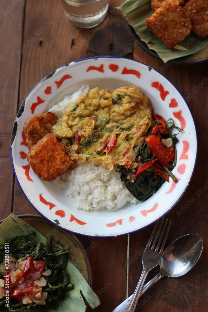 Nasi Rames Indonesian style lunch menu rice with fried egg, tempeh, and ...