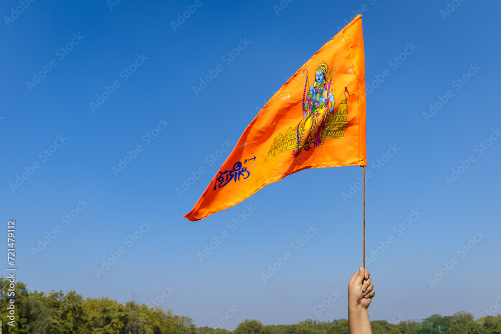 holy saffron flag with lord rama idol holing in hand with bright blue ...