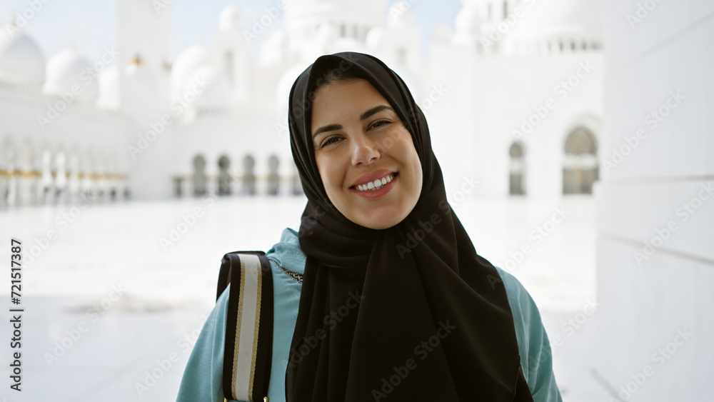 Happy woman in hijab smiling at sheikh zayed grand mosque in abu dhabi ...