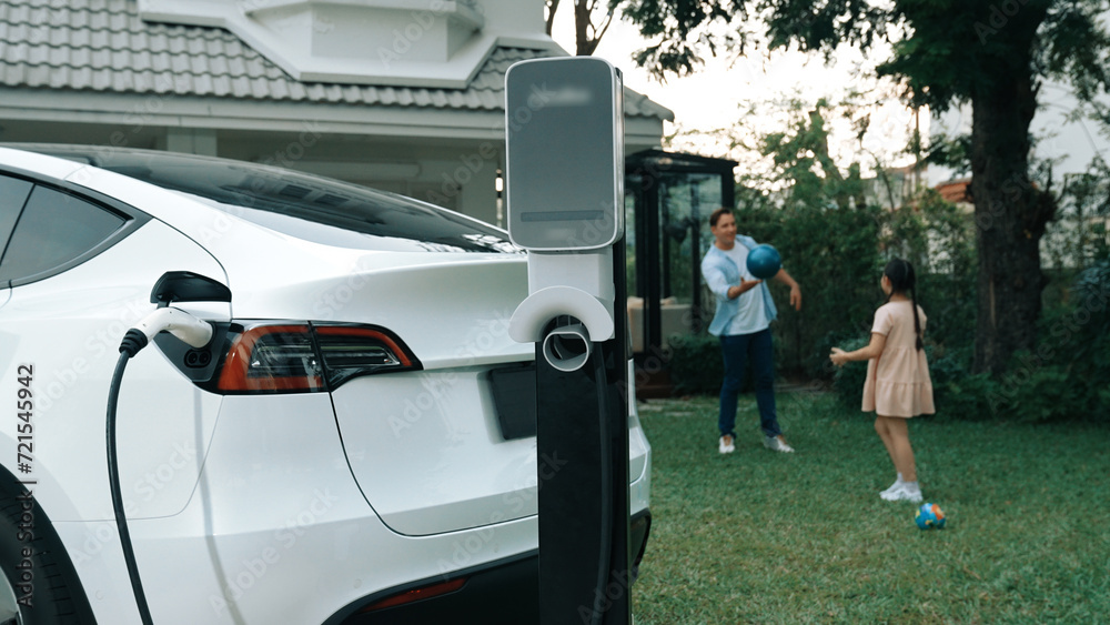 Electric vehicle recharge from home charging station on background of ...