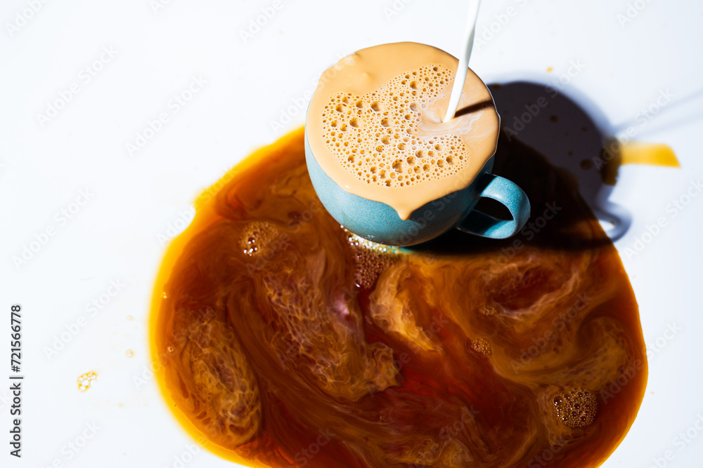 A green teacup filled to the rim with creamed coffee spilling out into ...