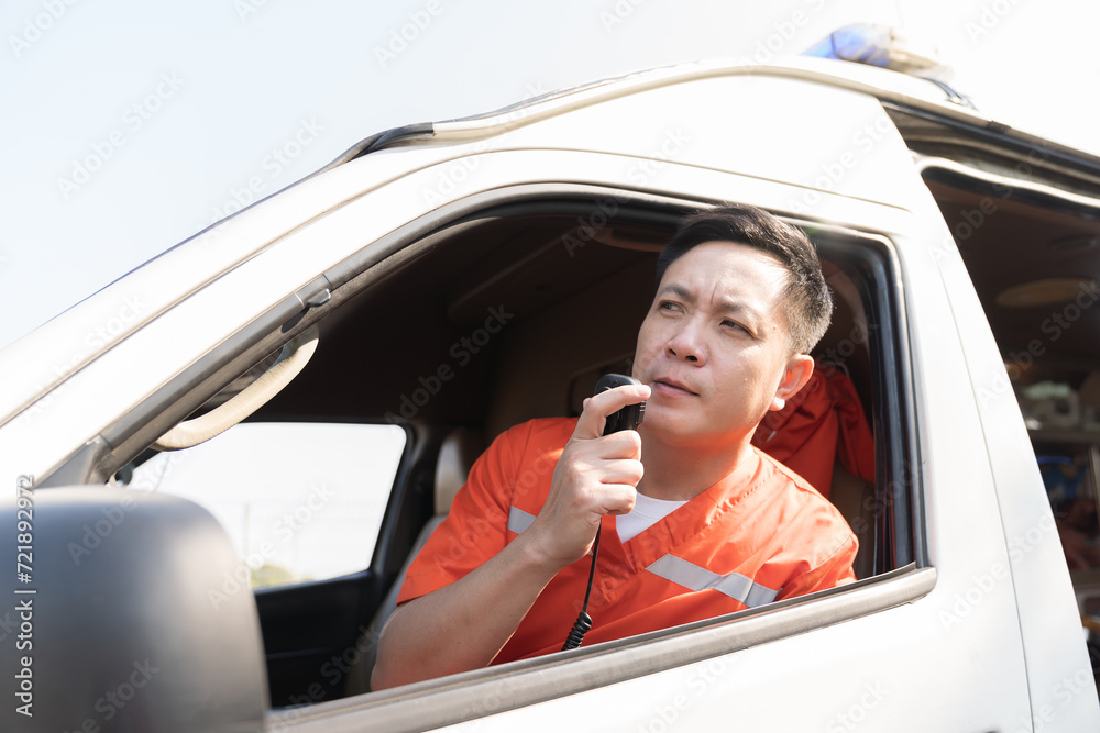 Asian male ambulance staff member in his ambulance car. He is wearing ...