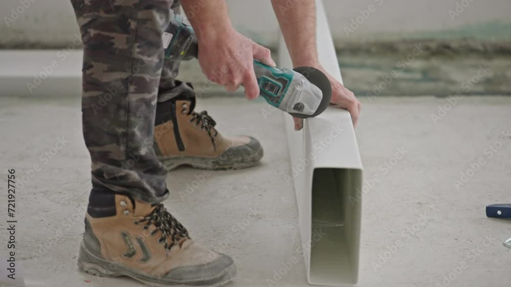 The master cuts off a plastic ventilation duct with an angle grinder ...