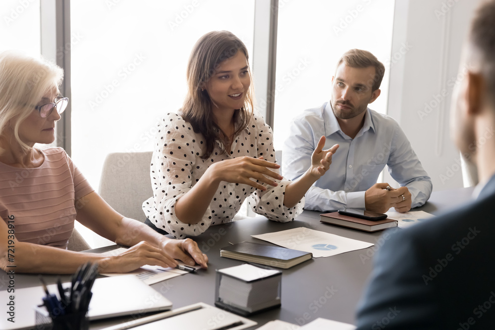 Positive pretty young business professional woman talking to partners ...