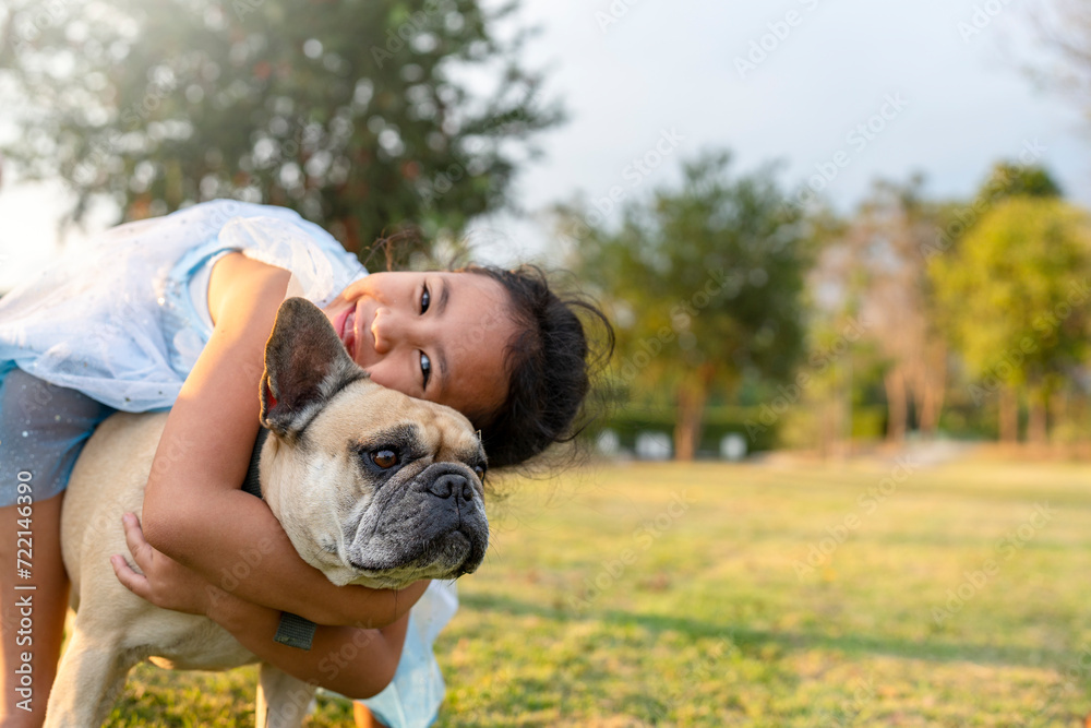Smiling child hugging her dog at field. Stock Photo | Adobe Stock