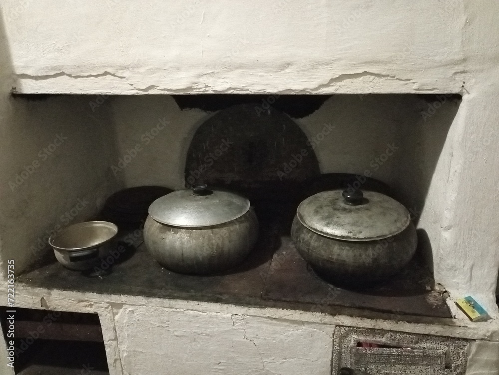 An old stove for cooking on wood, on which there are pots made of thick ...