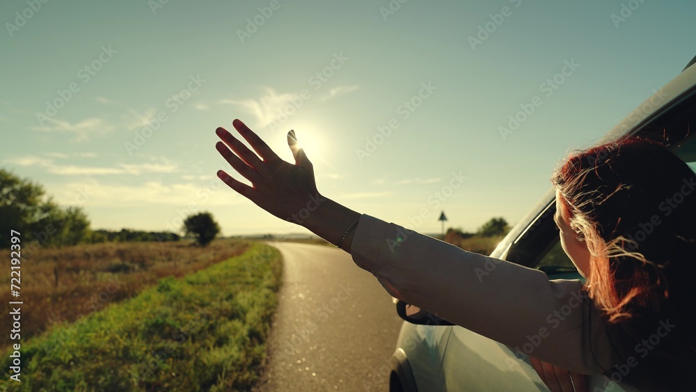 girl rides car with her hand out window, sun glare sunset, wind face ...