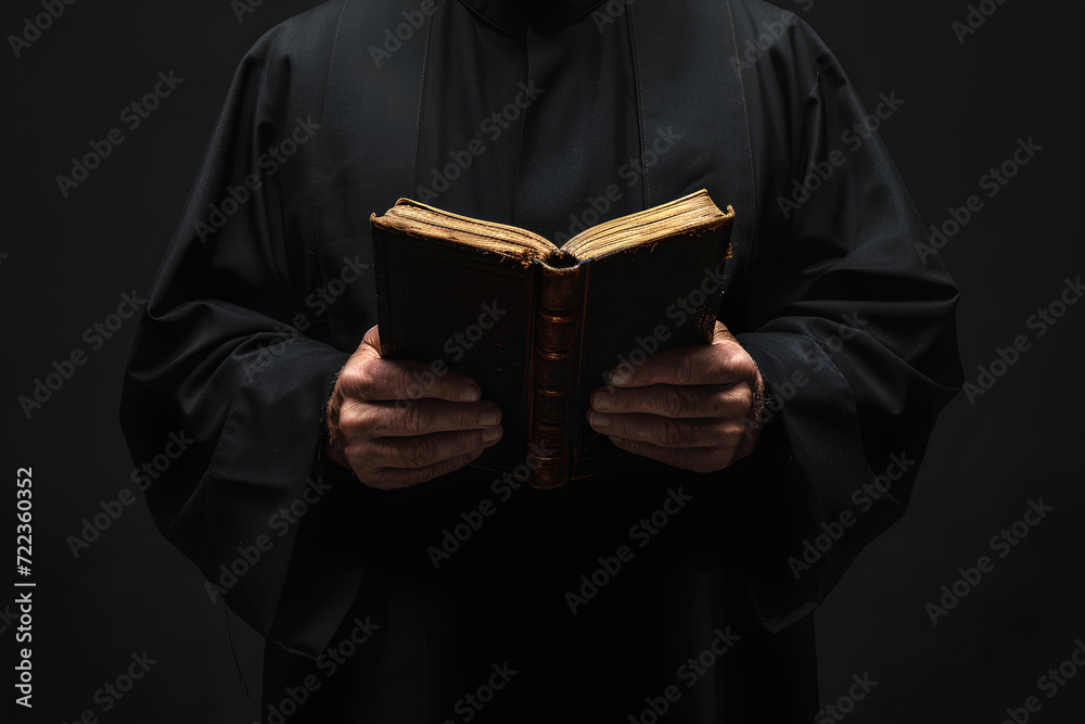 Catholic priest in black cassock robe holding the Holy Bible, isolated ...
