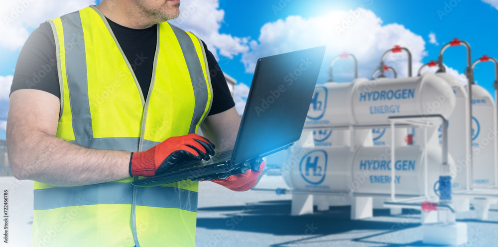 Hydrogen power plant technologist. Man with laptop near h2 gas tanks ...