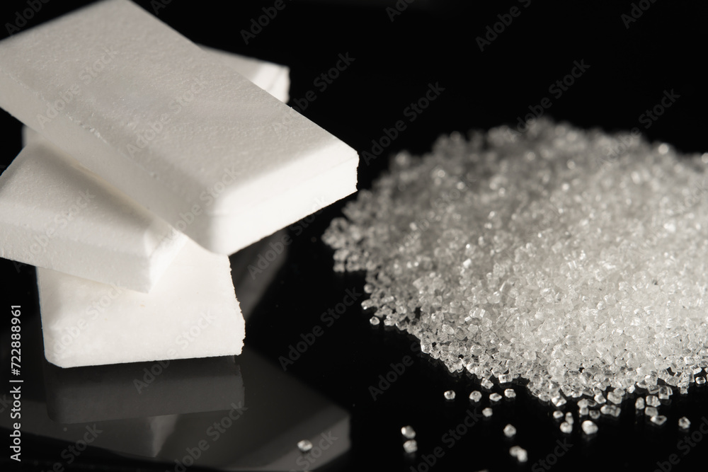 A stack of dextrose glucose tablets and a pile of white granulated ...