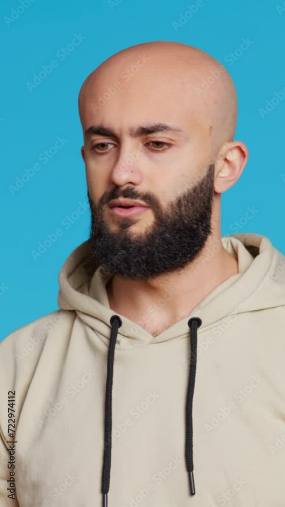 Vertical Video Young guy gesturing no sign over studio background ...