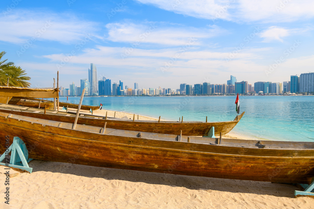Traditional Arabic boats docked on a sandy beach at Marina Mall Island ...
