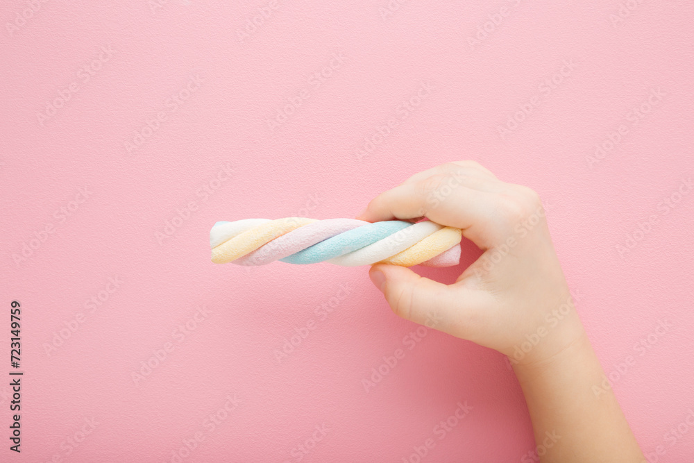 Little girl hand fingers holding colorful swirl soft marshmallow candy ...