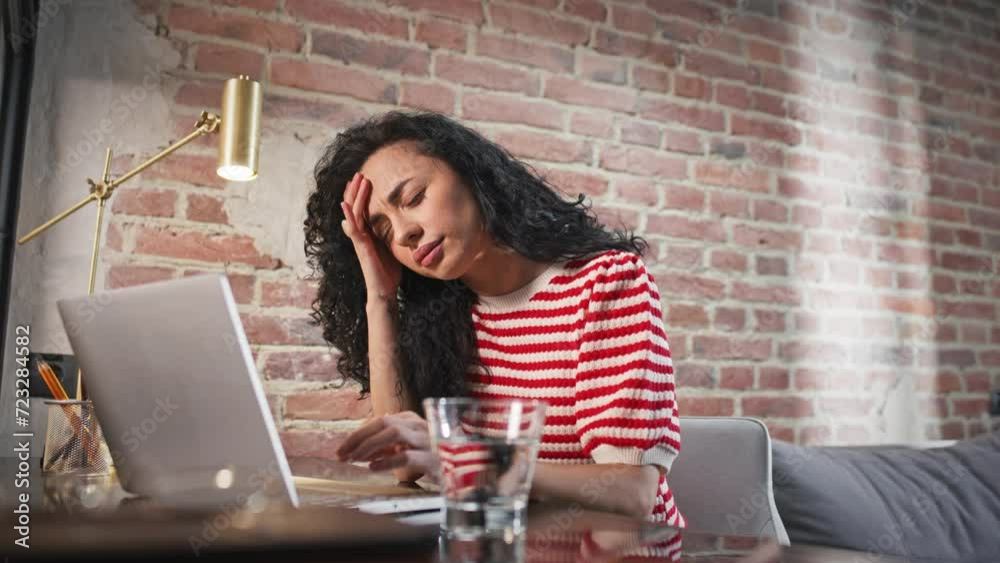 Focused Caucasian woman having headache while working remotely on her ...