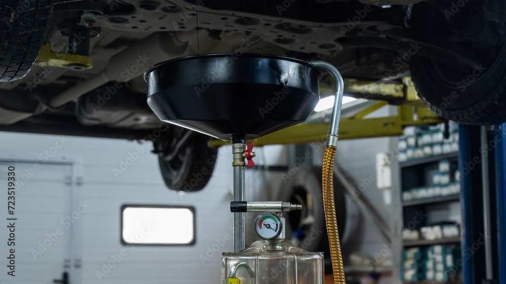 The process of changing the oil in a car engine. Draining old dark used ...