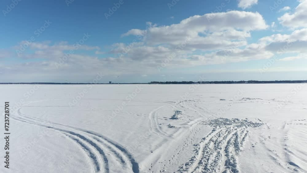 Flying backward with a drone, away from the kitesurfer on the white ...