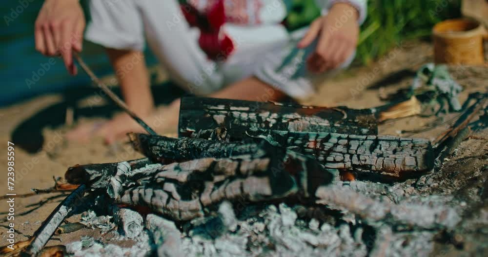 smoldering logs in ritual fire, young Slavic man performing old ...