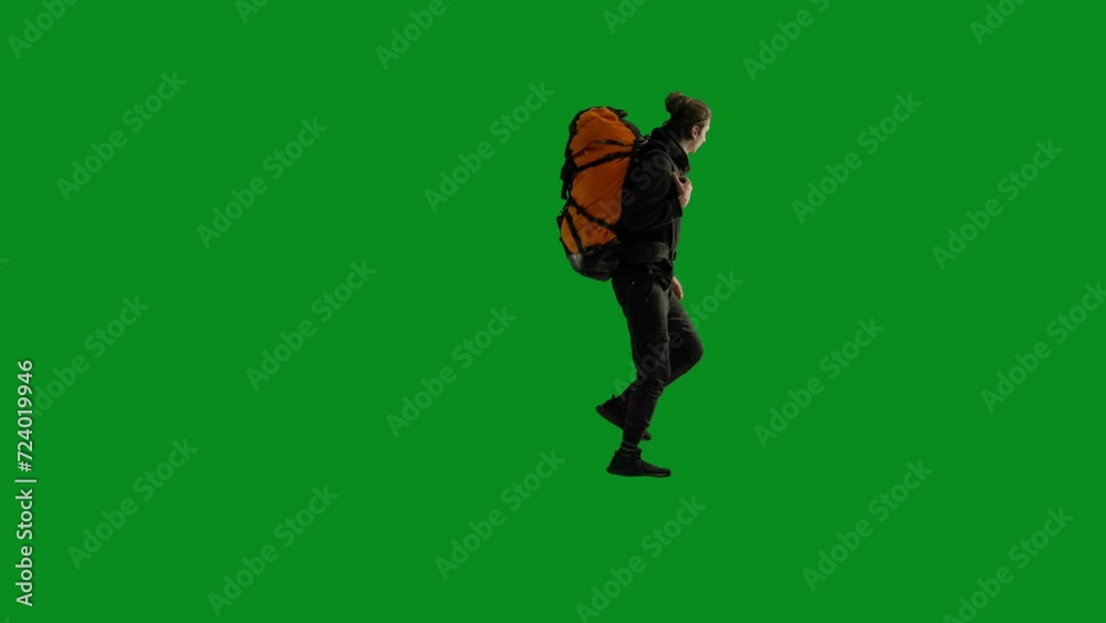 A male hiker with a backpack on his back climbs up. Side view of a man ...
