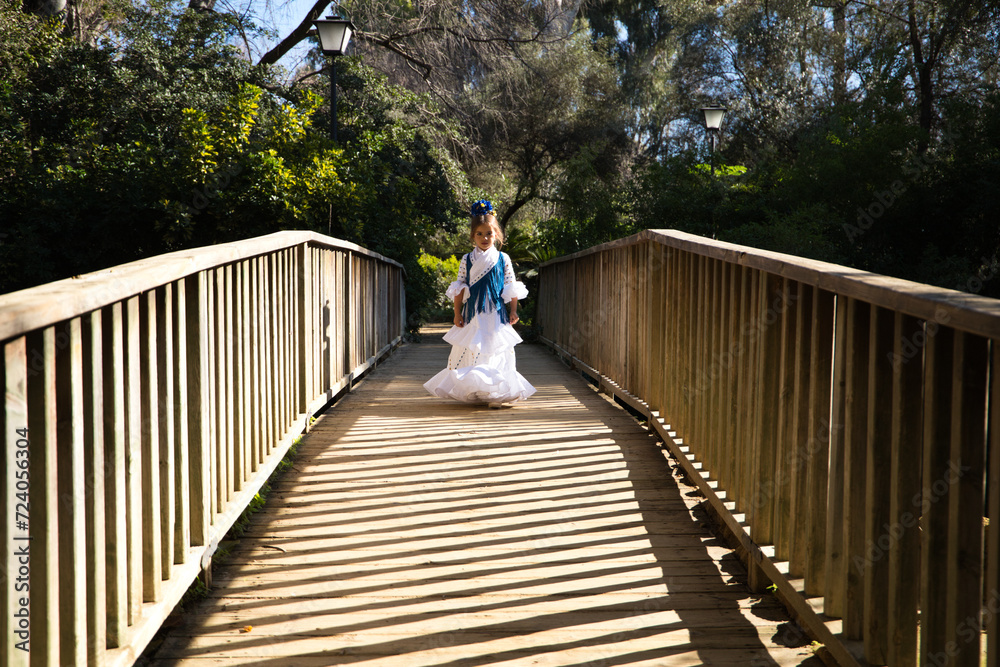 A pretty girl dancing flamenco in a typical gypsy dress with frills and ...