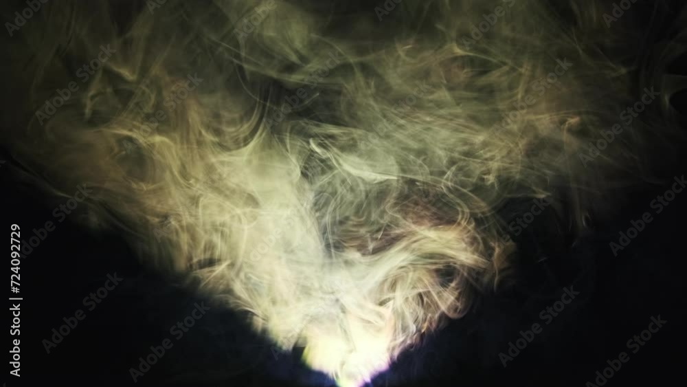 Colorful projector rays in smoke on black background. The radiant beams ...