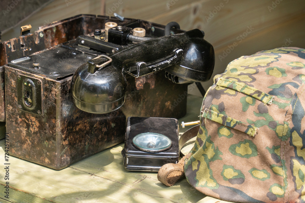 Old WWII military phone with flashlight and camouflage military helmet ...