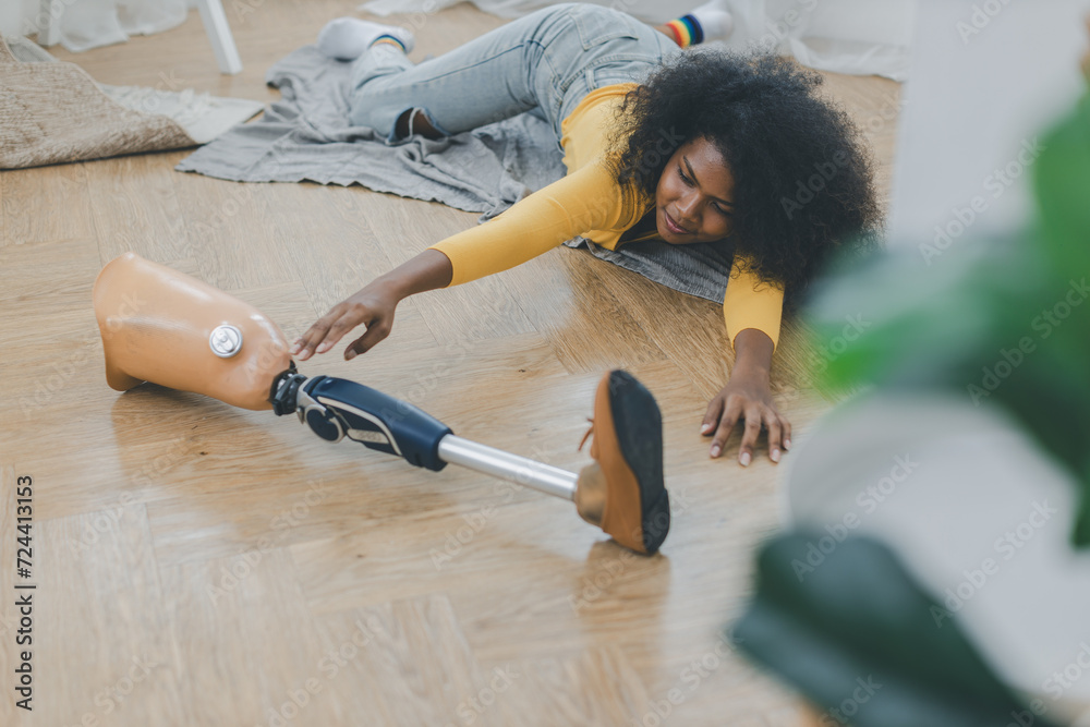 Woman with trying catch prosthetic leg on floor in bedroom. People with ...