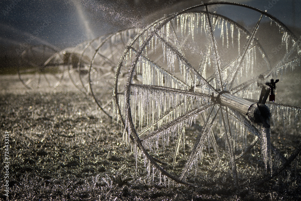 Ice cycles on a frozen wheel line irrigation sprinkler system after an ...
