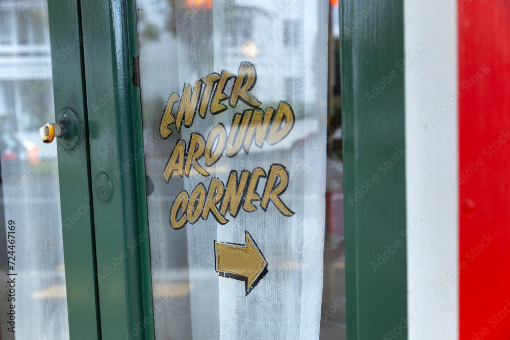 Sign on restaurant door and window sayong enter around corner. Fifties ...