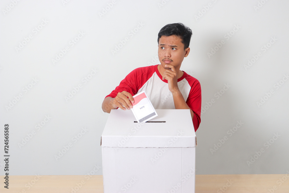 Portrait of excited Asian man inserting and putting the voting paper ...