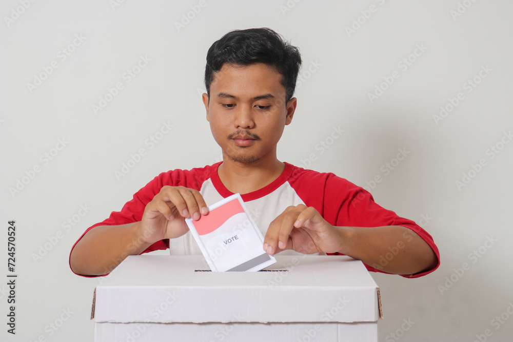 Portrait of excited Asian man inserting and putting the voting paper ...
