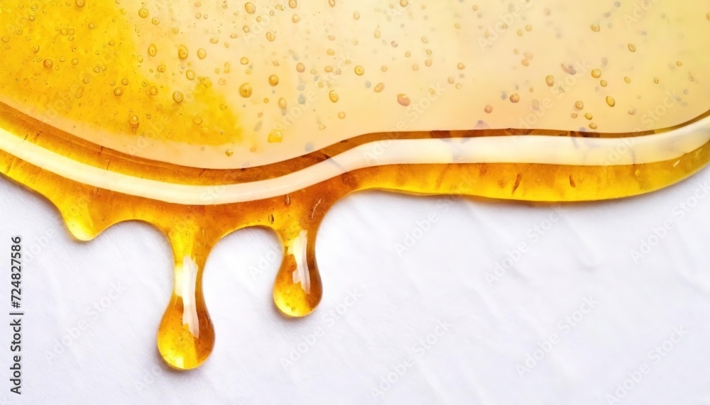 Honey dripping from a wooden dipper over honeycomb on a plate. Syrupy ...