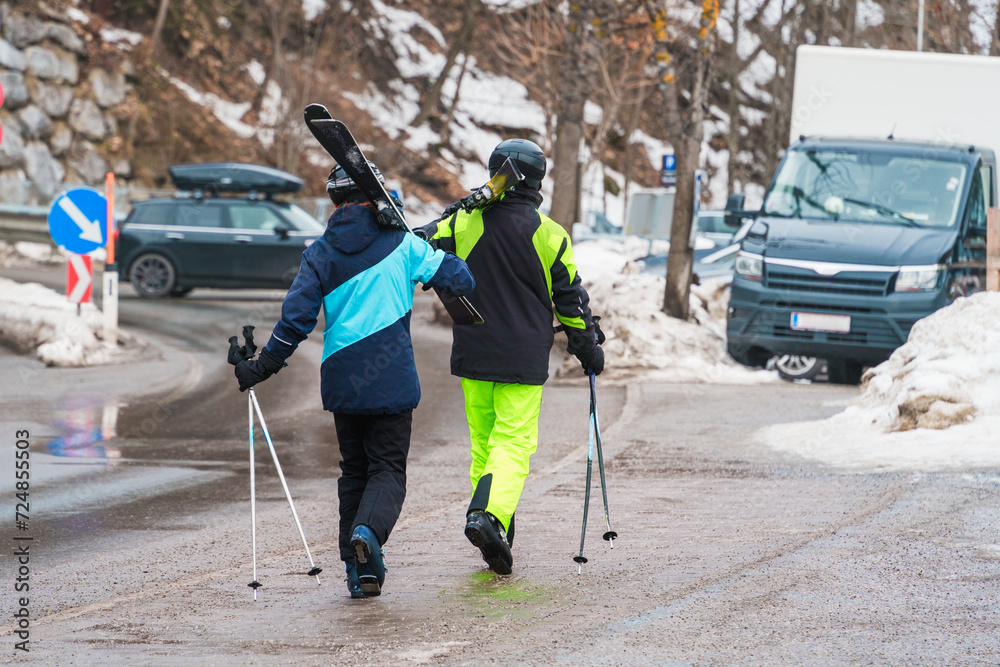 Skiers walk on a melting snow path, a vivid portrayal of the impacts of ...