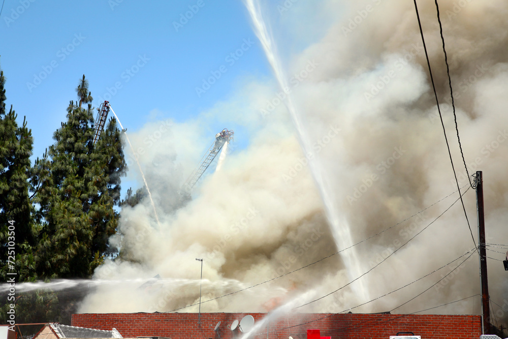 Firefighters battling a blazing building that is on fire with lots of ...