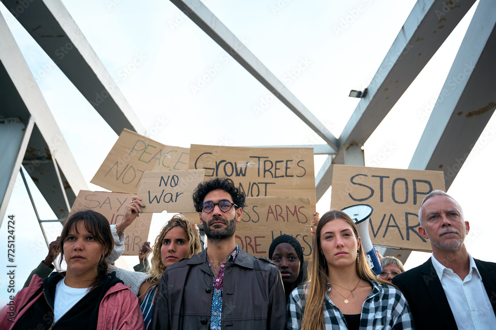Serious diverse group of people demonstrating against the war and ...