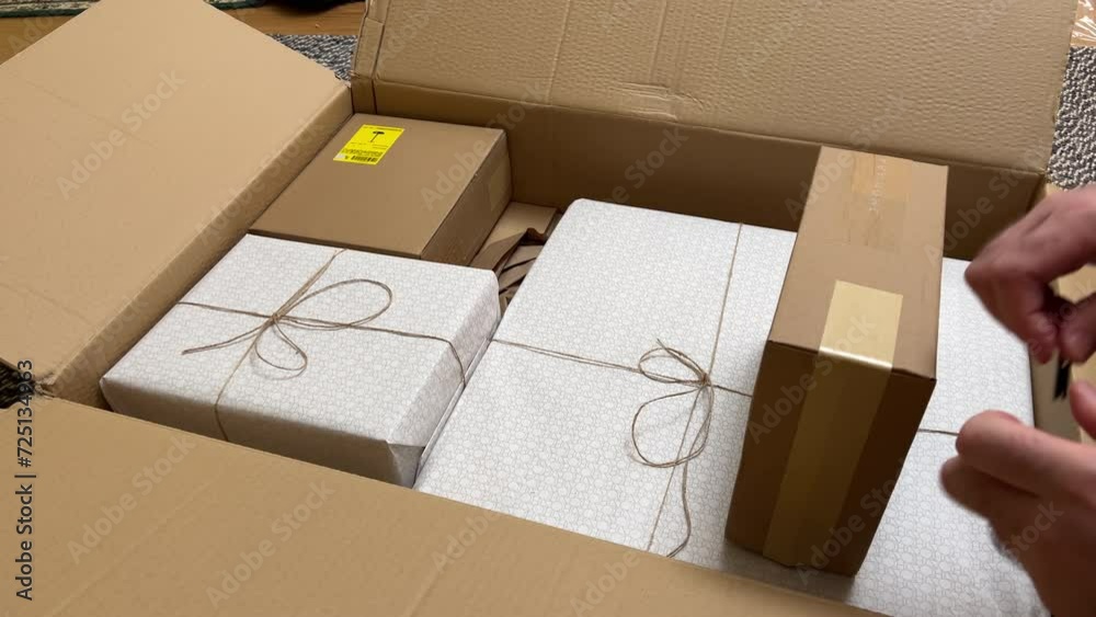Vidéo Stock male carefully unboxing a large box, revealing multiple ...