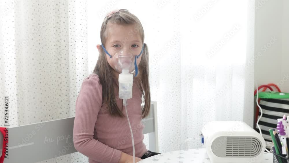 Cute little girl in the mask of an inhaler. Procedure of inhalation at ...
