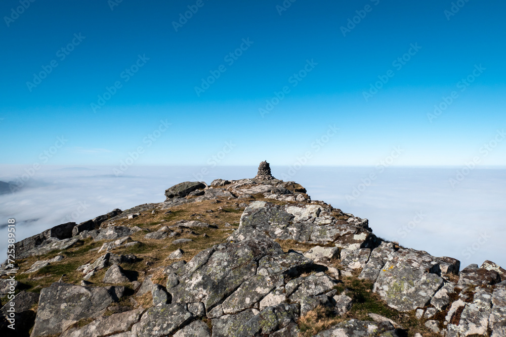 Entre brumas e mistérios: Uma pirâmide de pedras no pico da montanha de ...