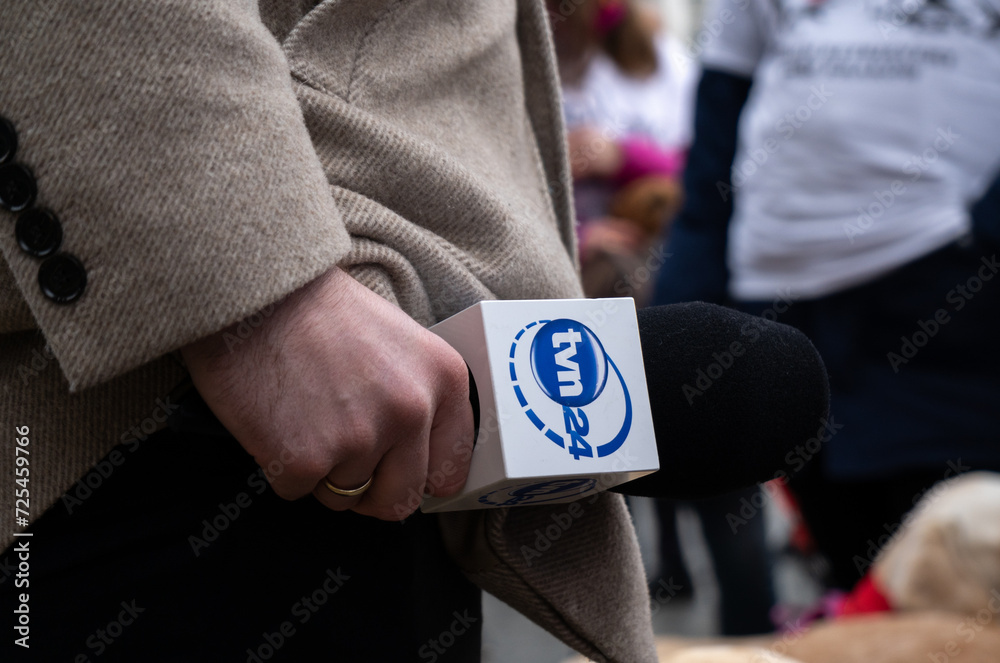 Reporter holding microphone with logo sign of TVN24 TV network company ...
