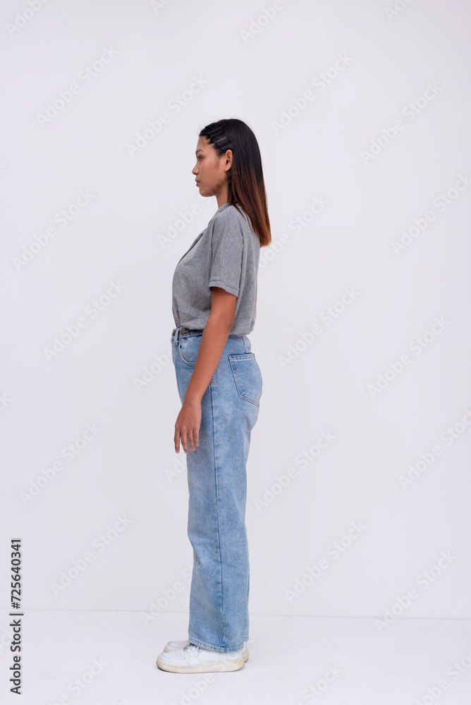 Full body profile side view of a serious Filipino woman wearing a grey ...
